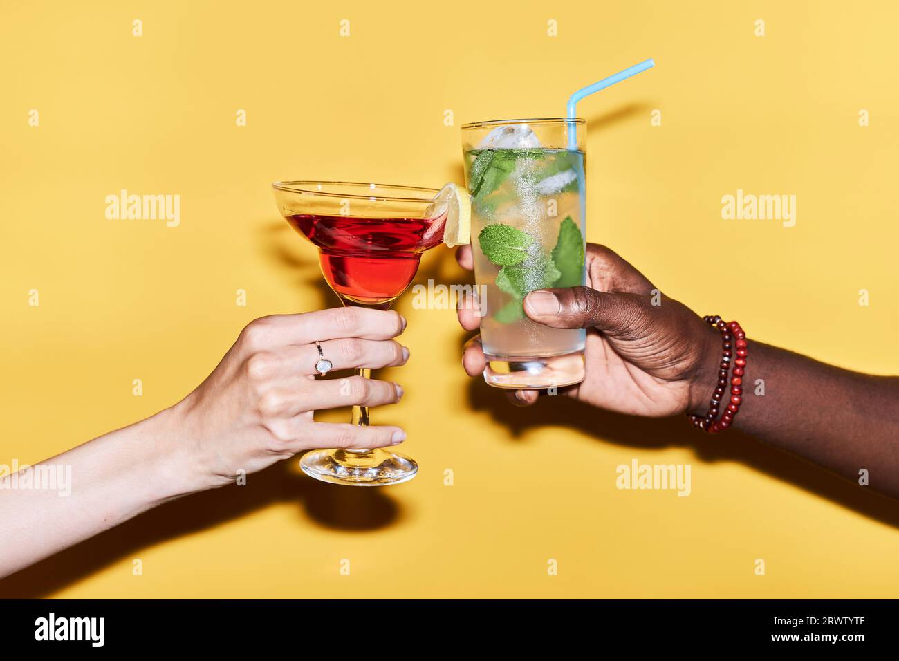 Minimal close up of multiethnic couple clinking cocktails against ...