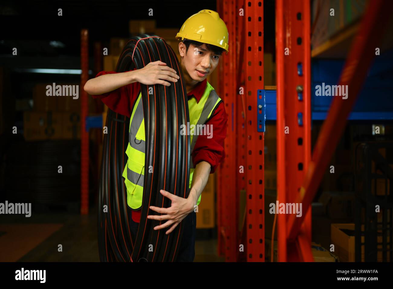 Strung man worker carrying plastic tube walking through factory ...