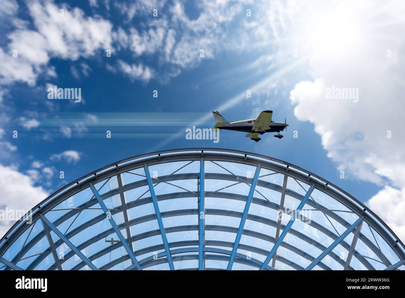 Small private propeller airplane in motion above a modern airport ...