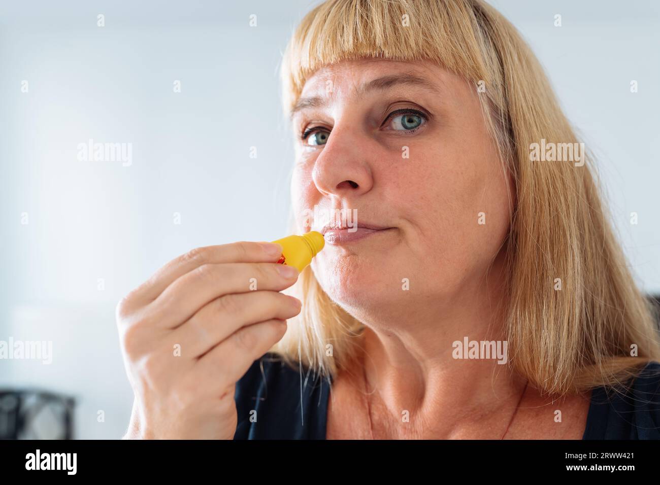 Portrait attractive blonde middle-aged woman taking care of facial skin, lips Stock Photo - Alamy