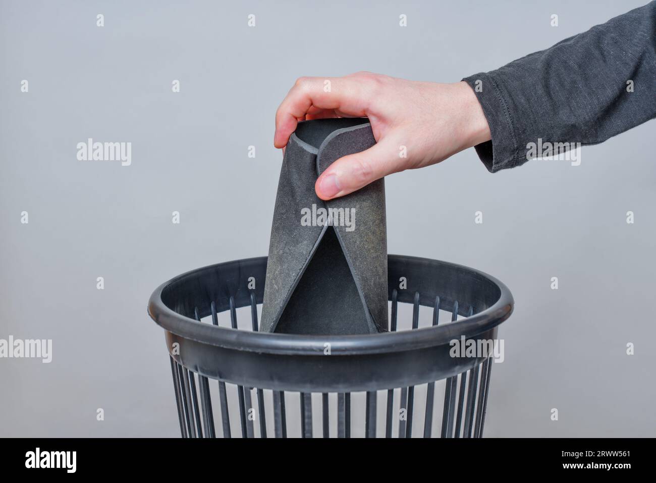 Person tosses a worn and well-used mouse pad into a trash bin Stock ...