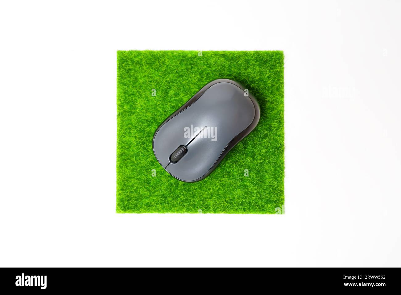 Top view of a computer mouse placed on a tiny square patch of green ...