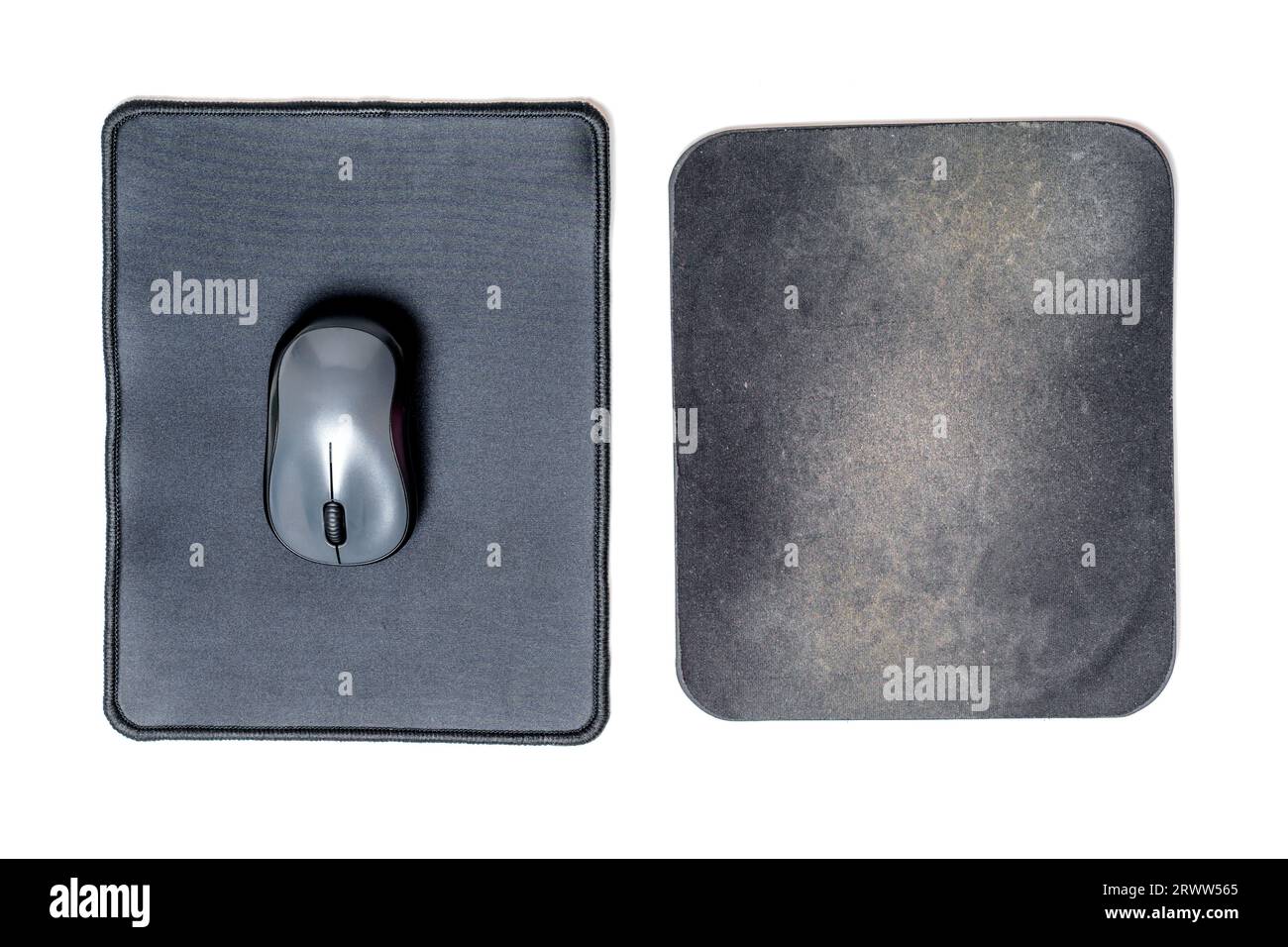 Brand new clean computer mouse pad and a well-used dirty one placed ...