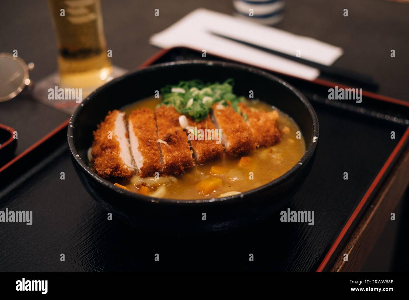 Close-up of black bowl with ramen soup and fried chicken katsu in a ...