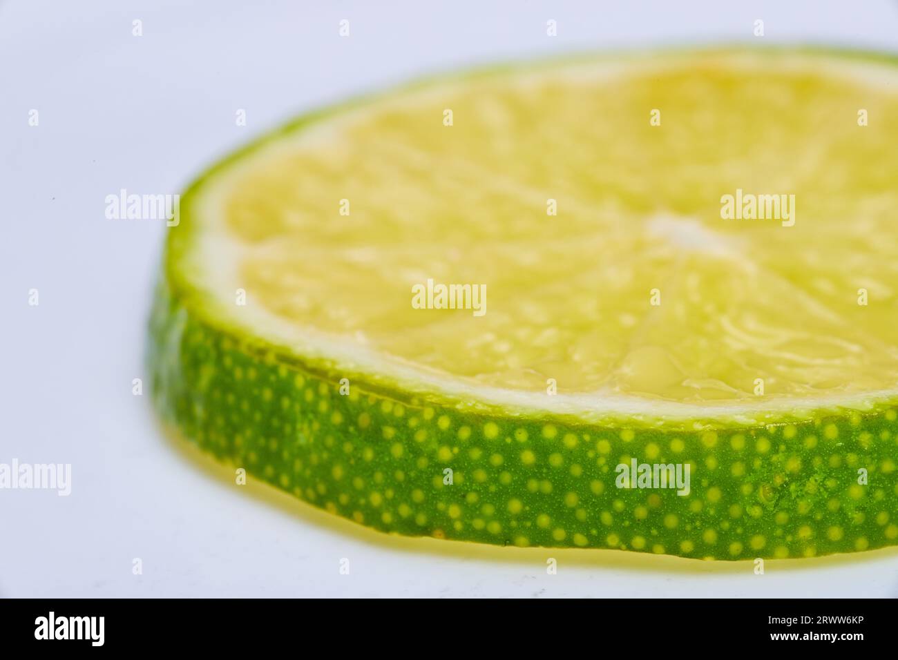 Macro side view of green lime slice against white background Stock ...