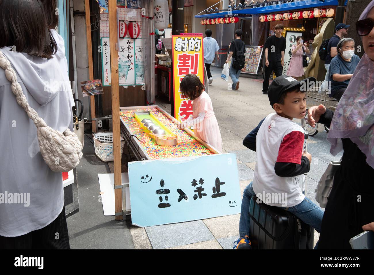 A girl enjoying bouncy ball scooping game Stock Photo - Alamy