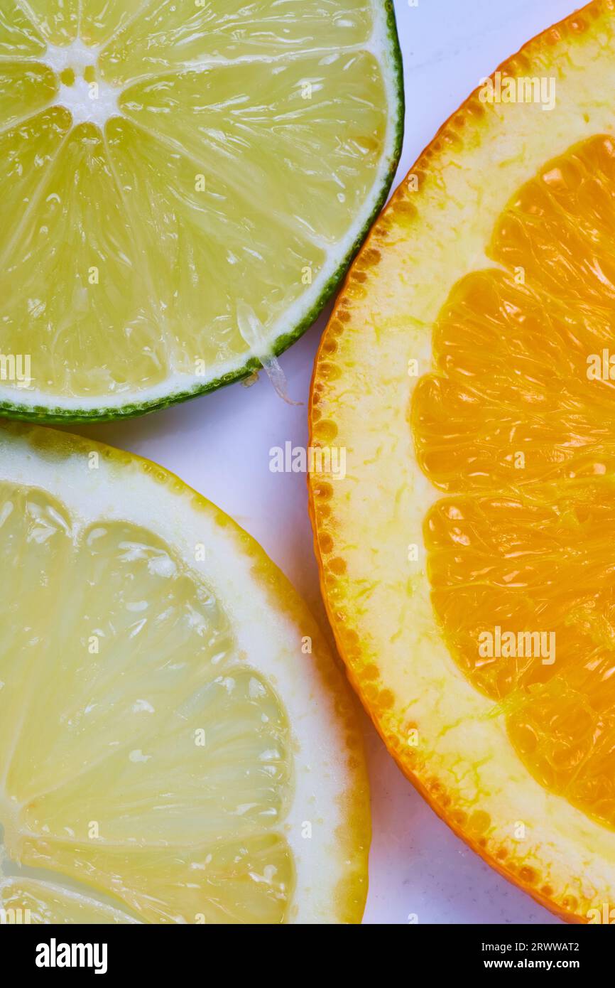 Three citrus fruit slices with curved corners coming together on white ...