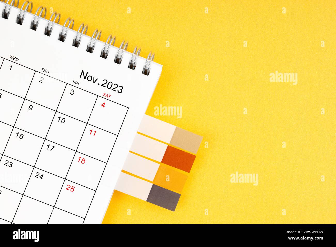 November 2023 Monthly desk calendar and blank adhesive note on yellow ...