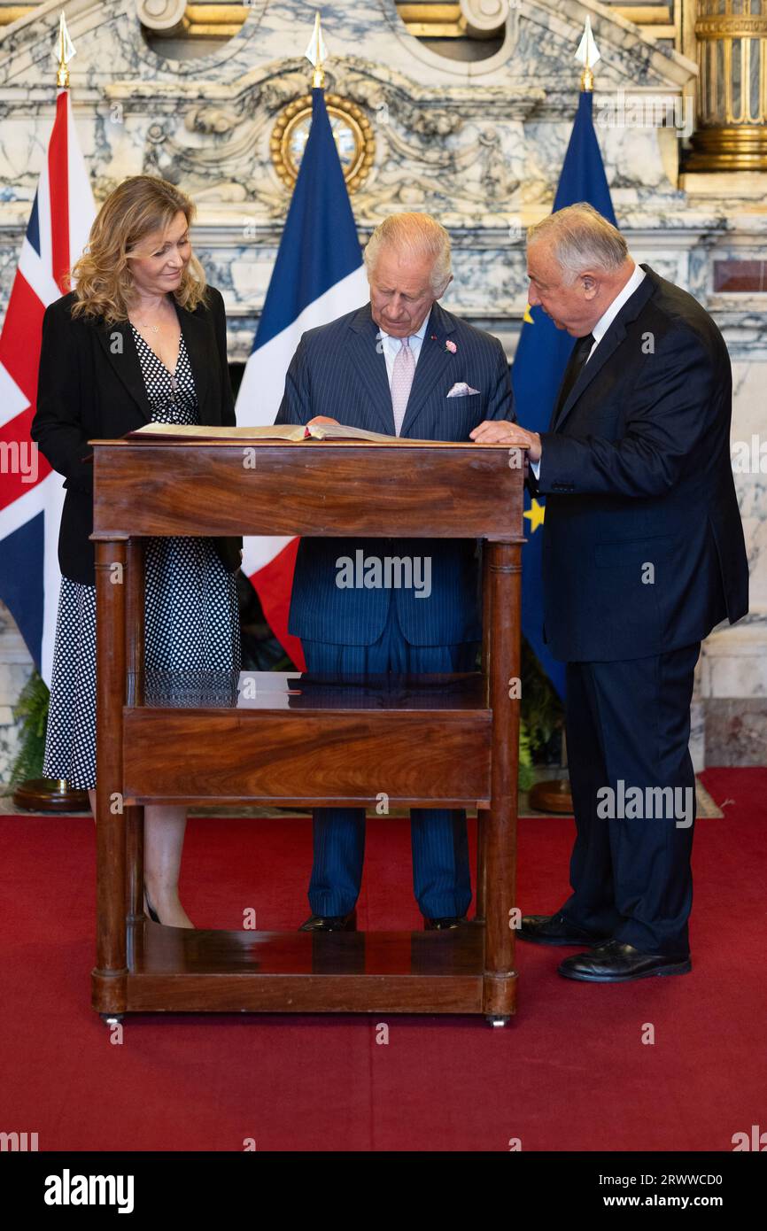Britain King Charles III sign a golden book next to President of the French National Assembly ...