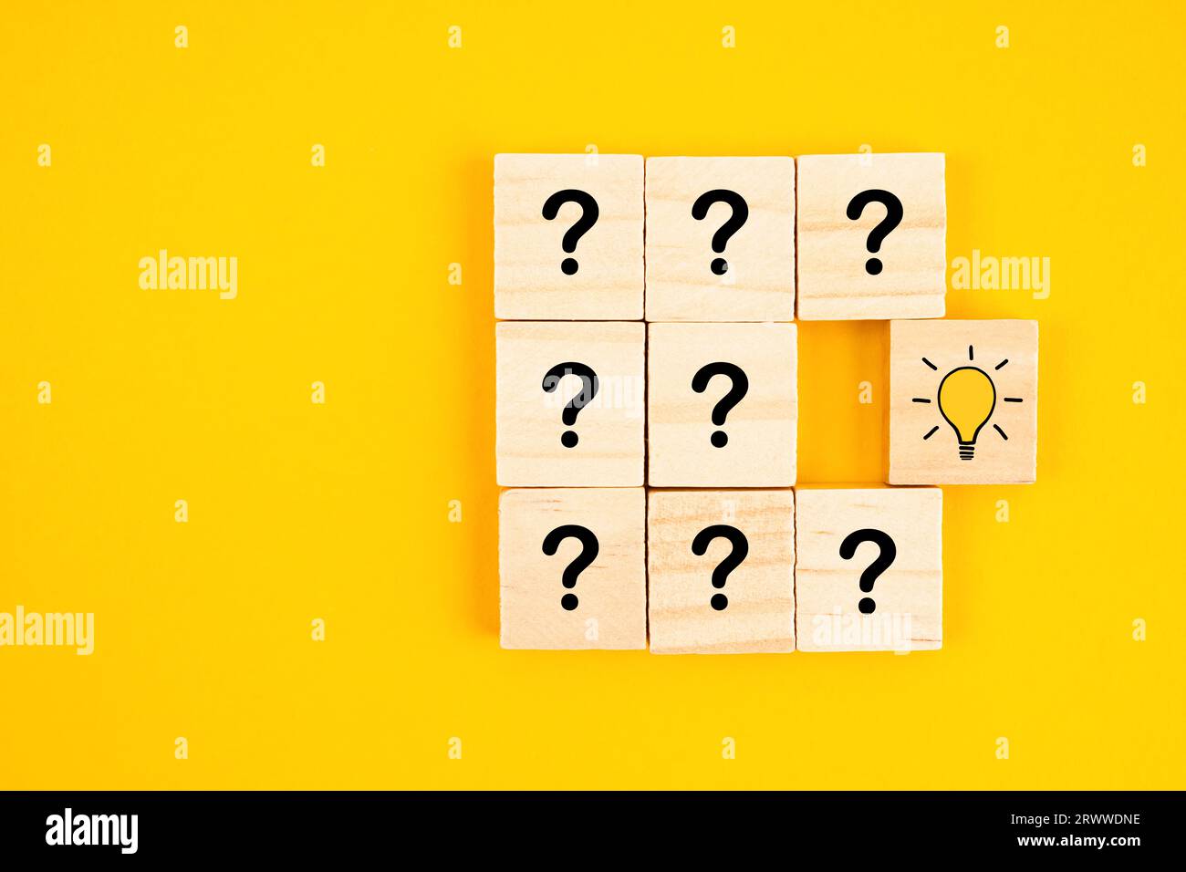 Wooden cube with hand drawn light bulb next to the cubes with question ...