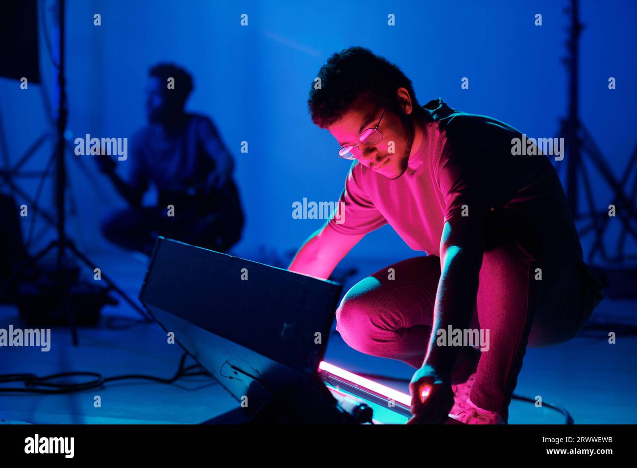 Professional operator setting the light before shooting in studio Stock ...
