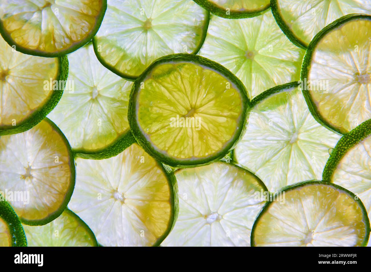 Pile of overlapping green lime slices created wall of limes in ...