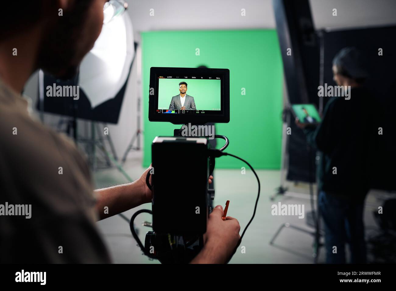 Rear view of professional cameraman shooting content for TV program ...