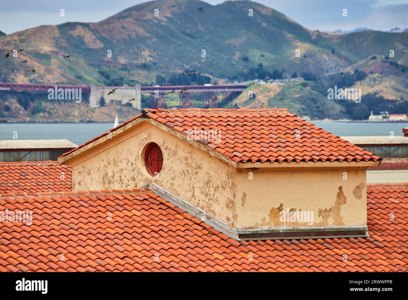 Cream colored building rooftop with circle window and orange clay ...