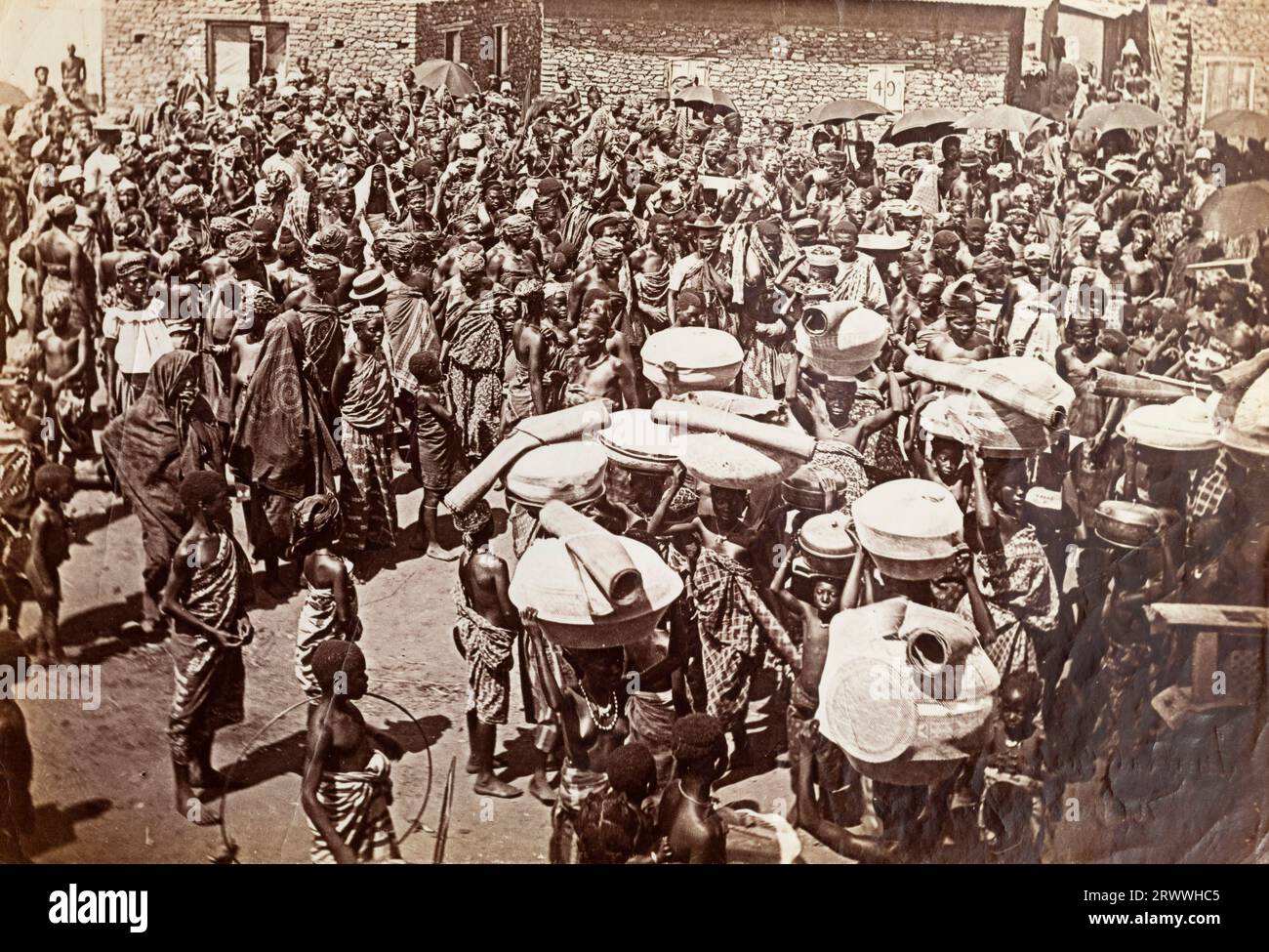 An overhead photograph of a large mourning party gathered in the street ...
