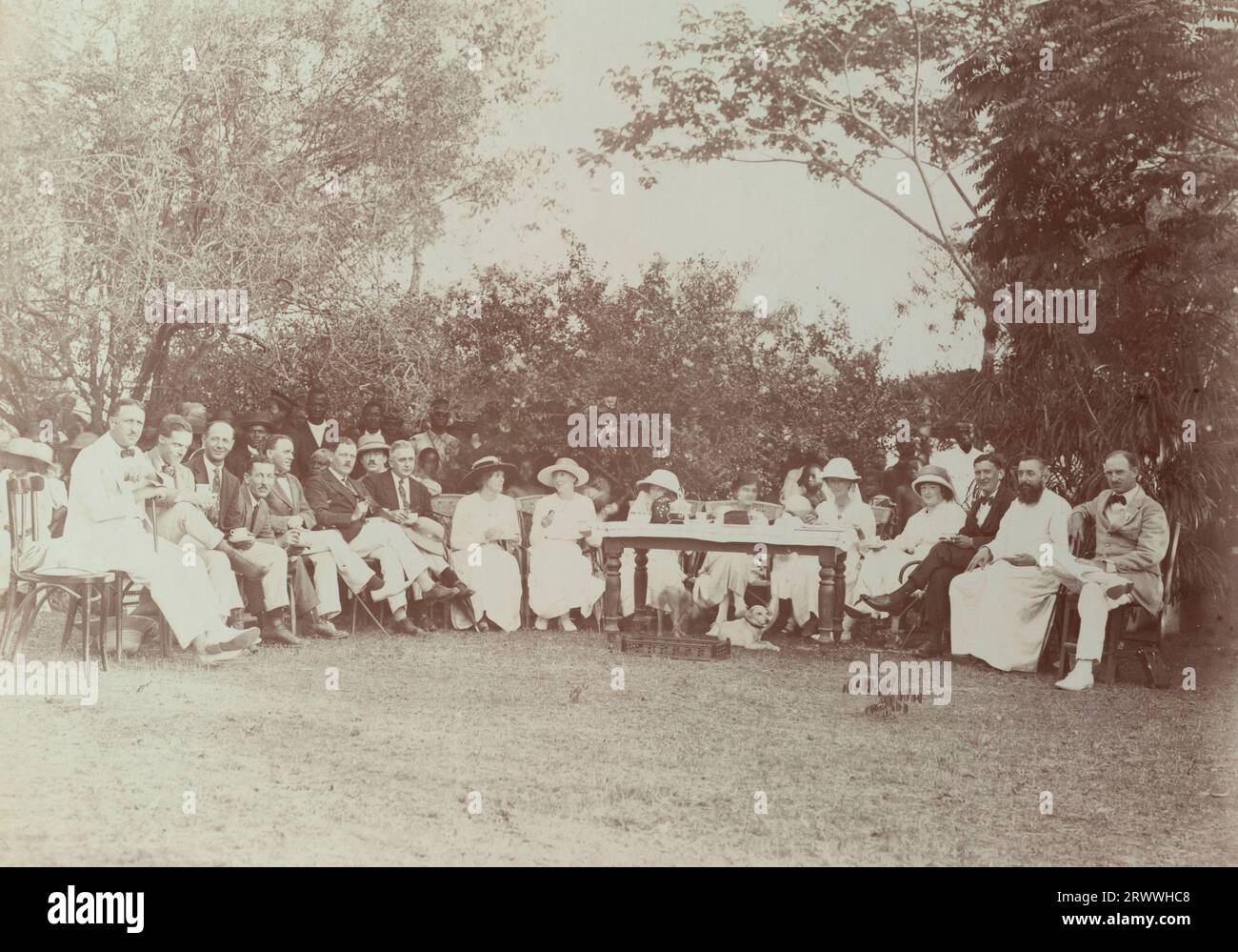 Large group photograph of smartly dressed staff at an outdoor tea party ...
