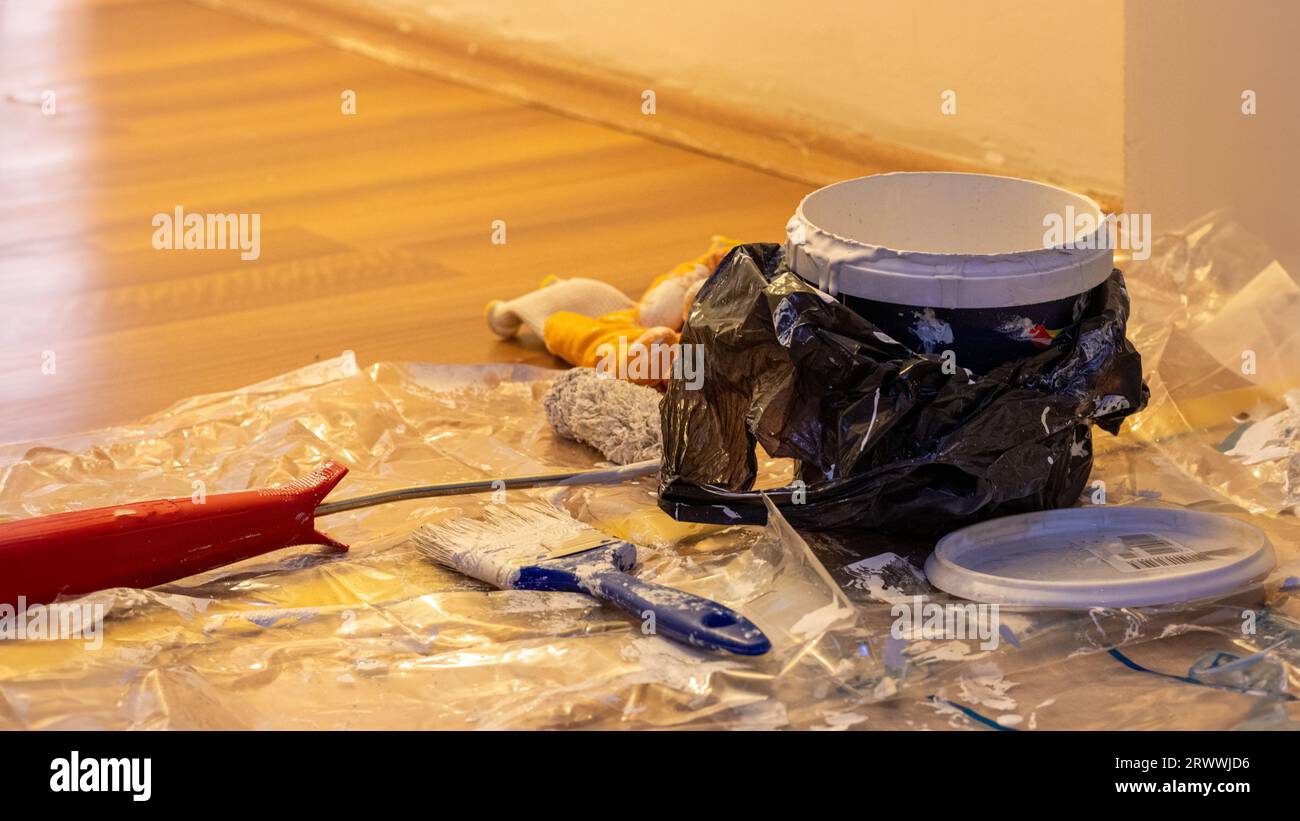 Home renovation in a modern house. Paint cans, brushes, and gloves ...