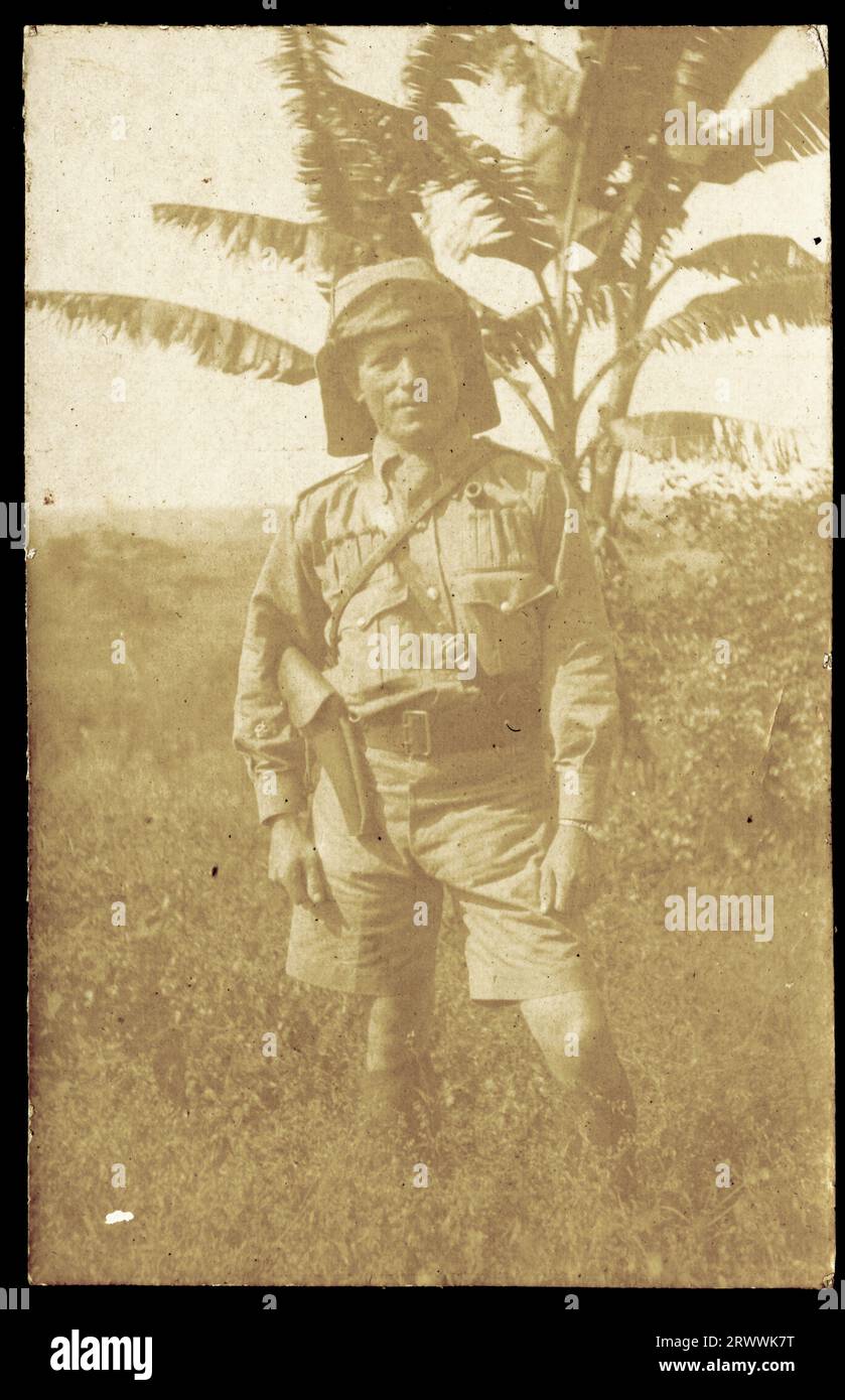 Portrait of a European officer in the shade of a palm tree. He is ...