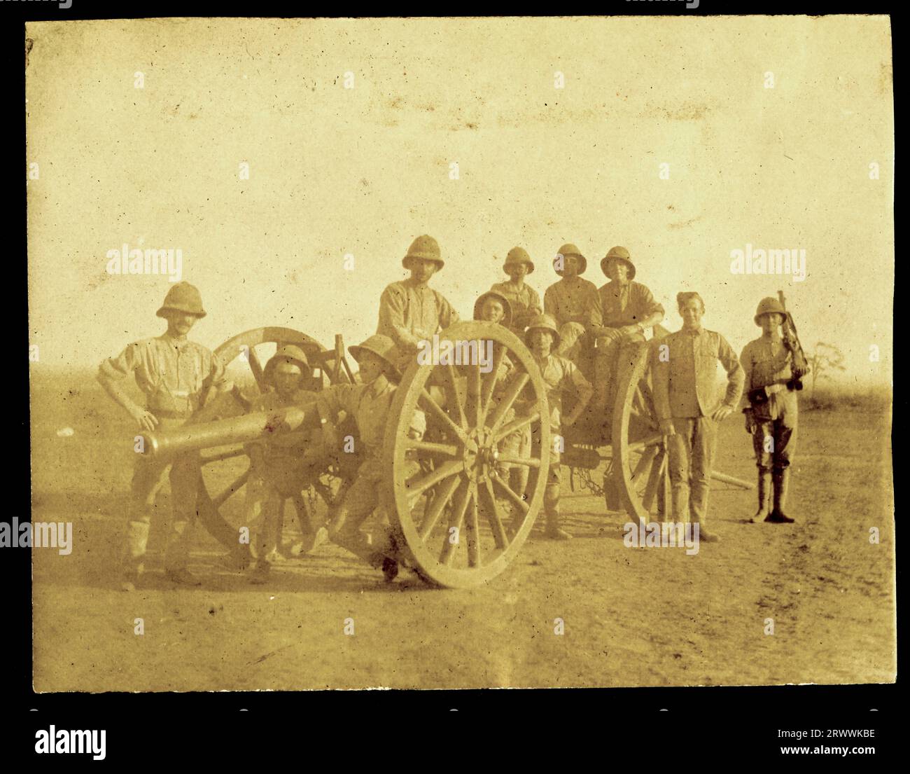 Eleven European soldiers in uniforms pose with a field gun and carriage ...