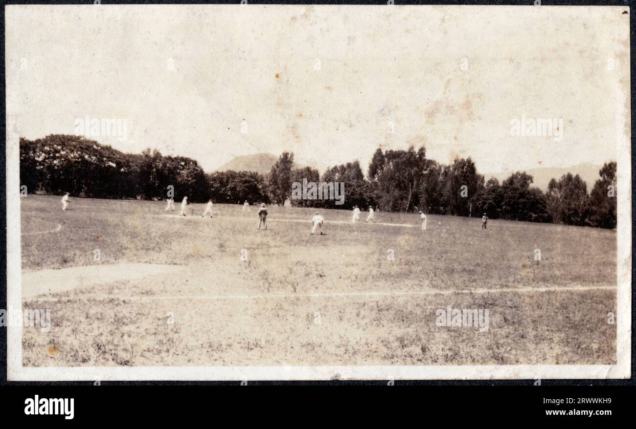 Landscape view of a cricket match on a grassy pitch with mountains ...