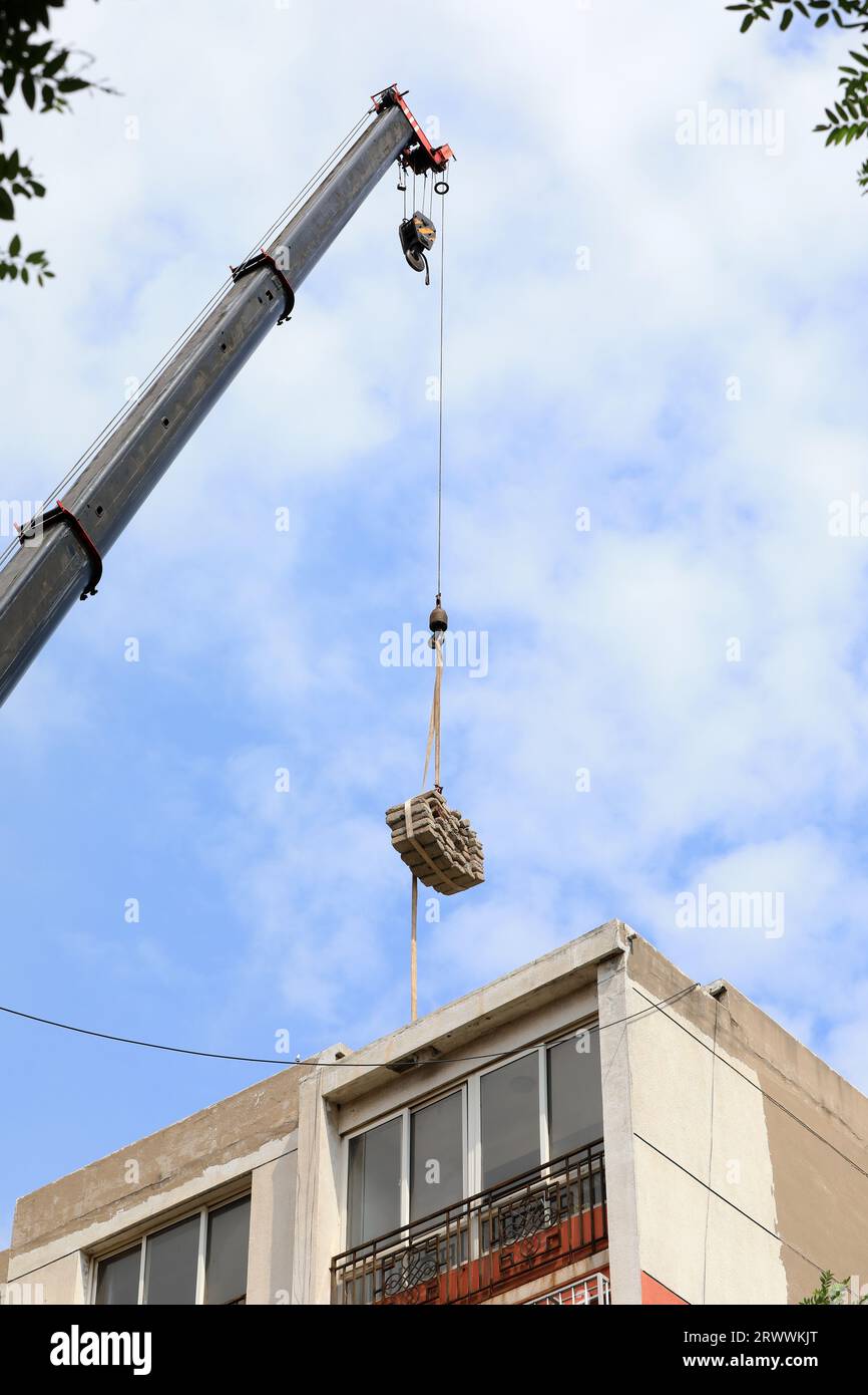 Crane lifting building materials, North China Stock Photo - Alamy