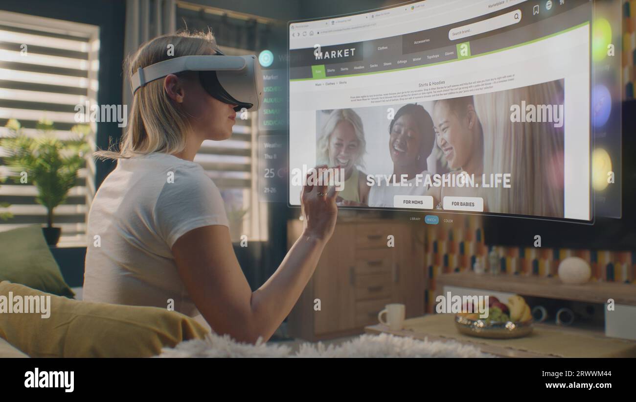 Woman in VR headset chooses clothes in online store chilling at home ...