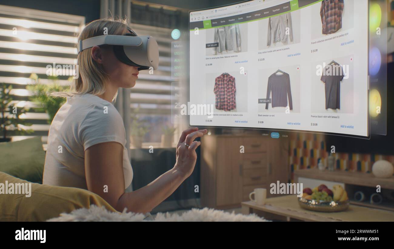 Woman in VR headset chooses clothes in online store chilling at home ...