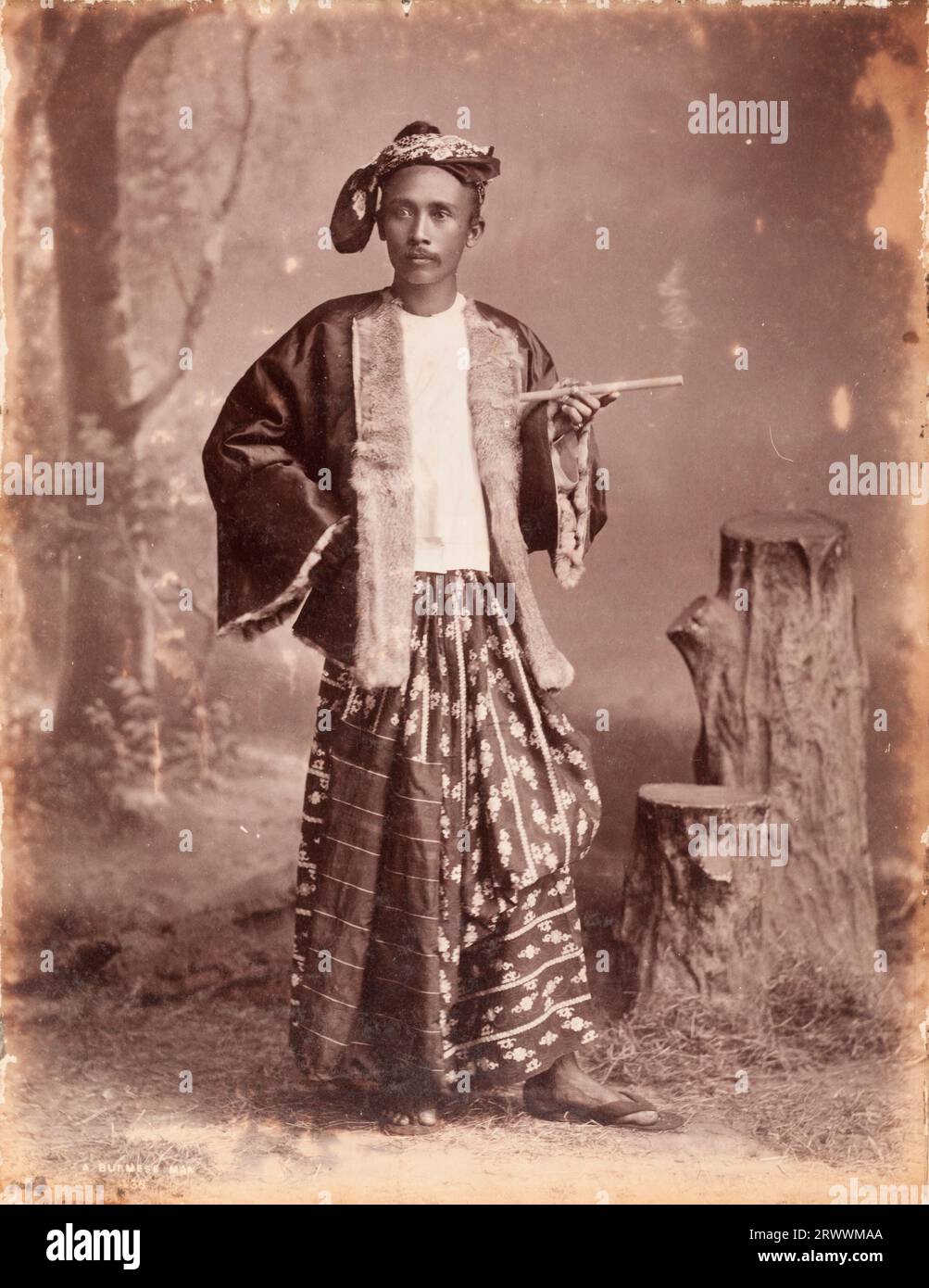 Portrait of a Burmese man in traditional dress including a longyi ...