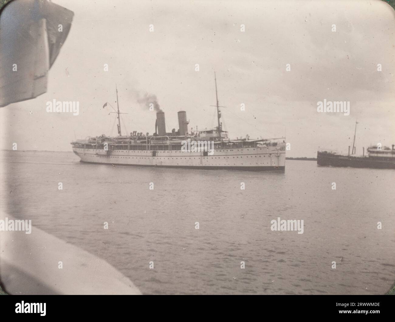 Front angled view of twin-funnelled, two-masted, medium-sized troopship ...