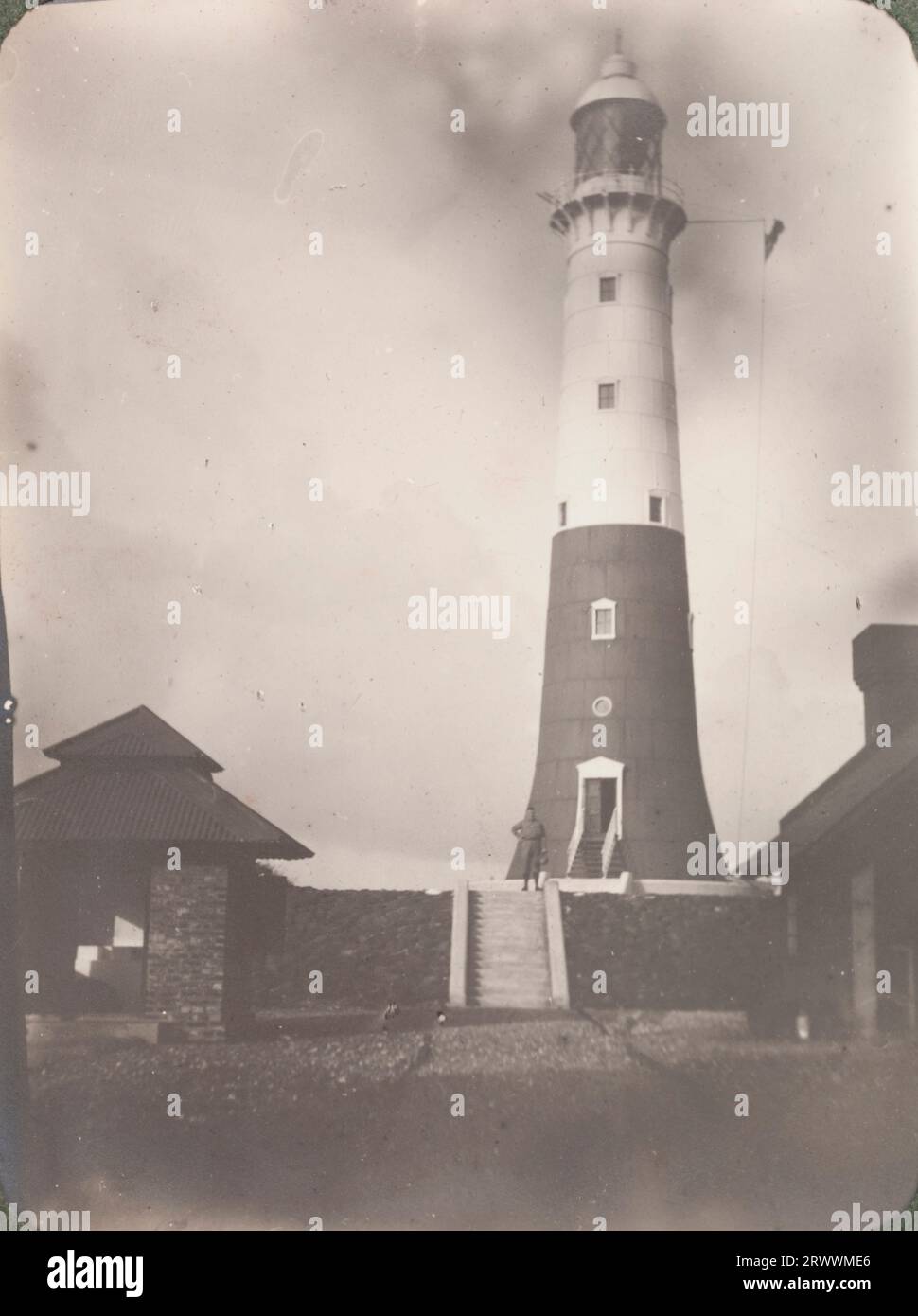 View of lighthouse and small figure to one side. Caption reads: Burma ...