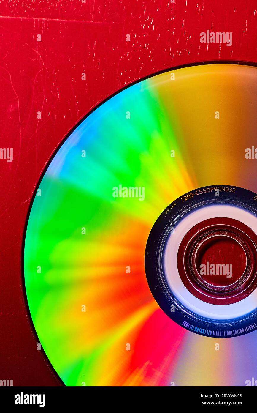 Colorful CD on red background with bursts of rainbow colored lights ...