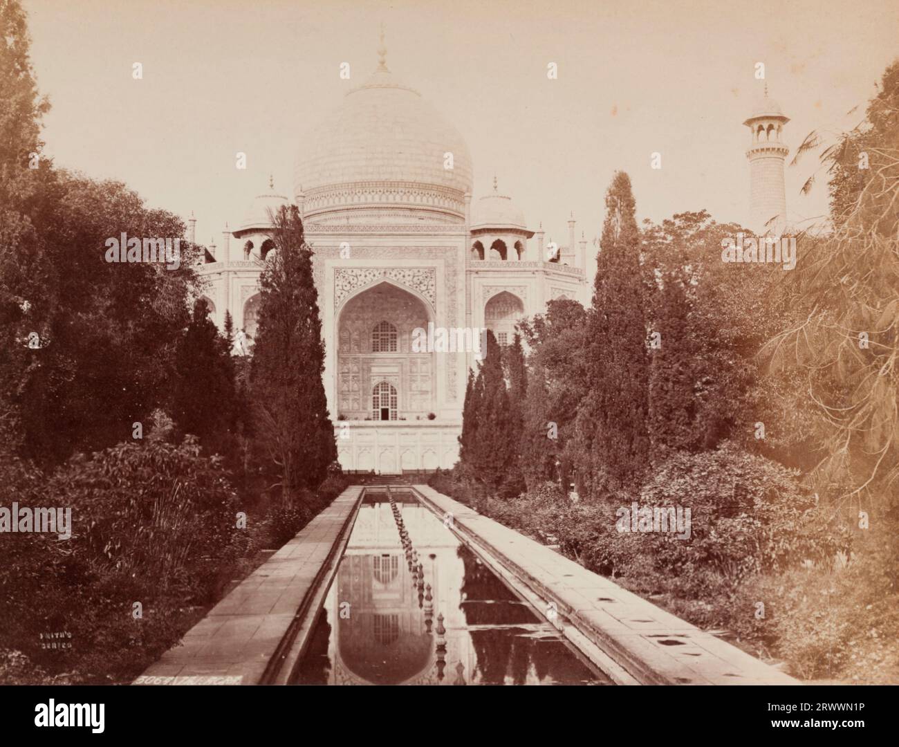 View of the Taj Mahal reflected in the courtyard pond lined with trees ...