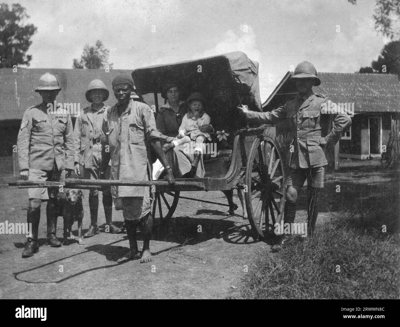 A rickshaw pulled by an African man pauses in the road outside two ...