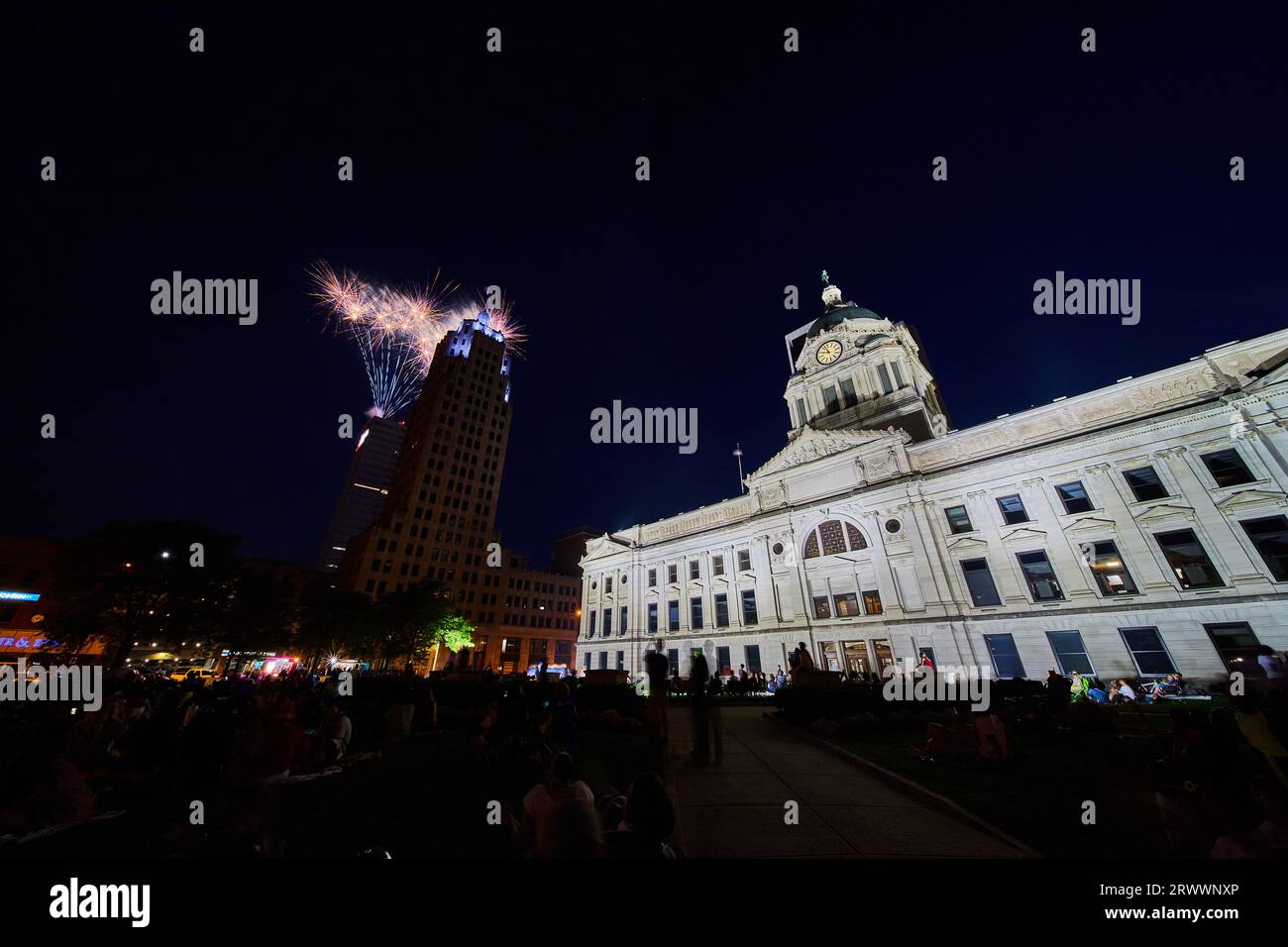 Fireworks at night behind Lincoln Tower with people crowding courthouse ...
