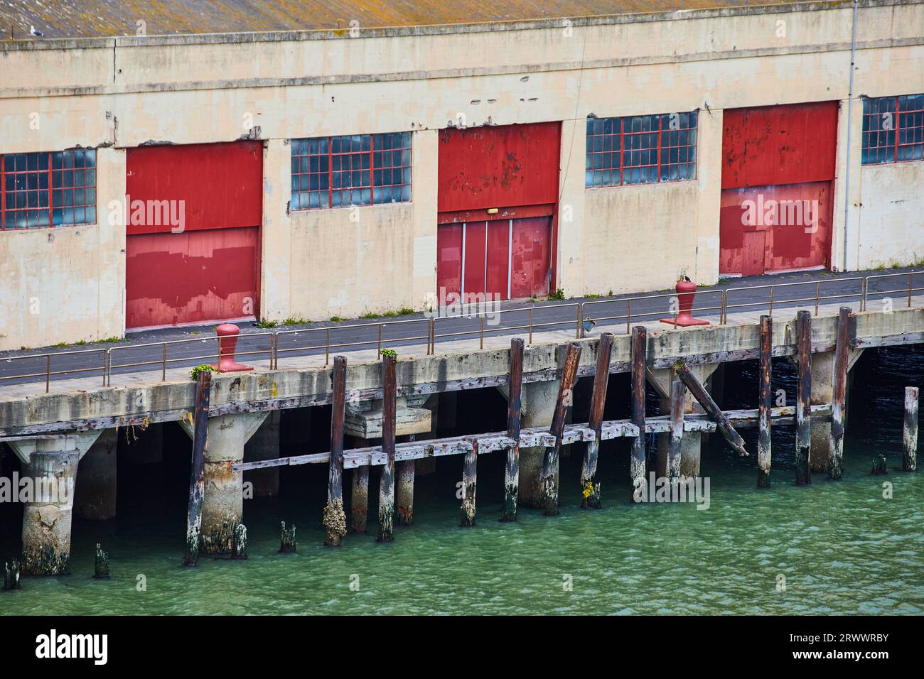 Red doors on pier warehouse with green San Fransisco Bay waters Stock ...