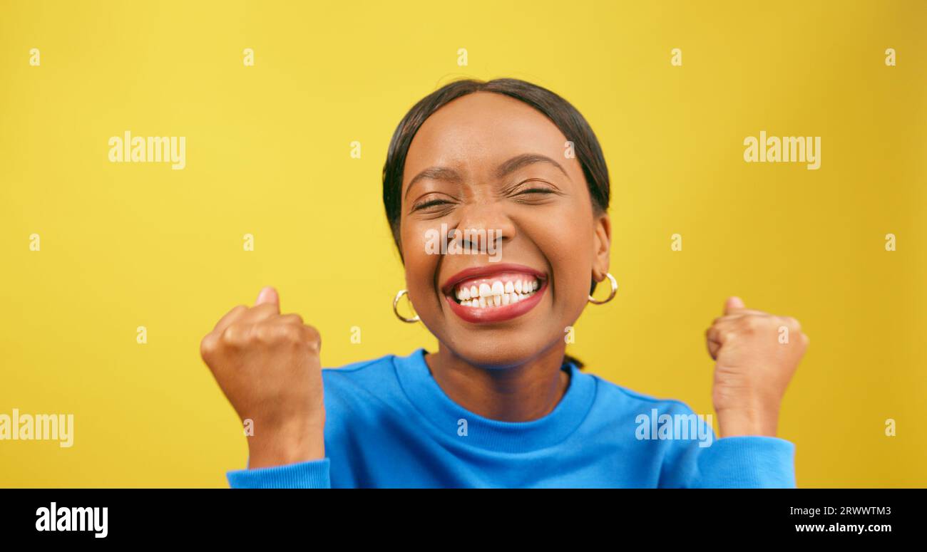 Excited woman cheers, winning happy dance, yellow studio background ...