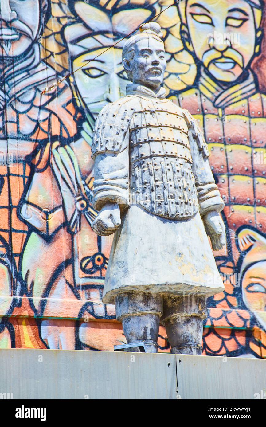 Chinese man statue standing in front of soldier mural Stock Photo - Alamy