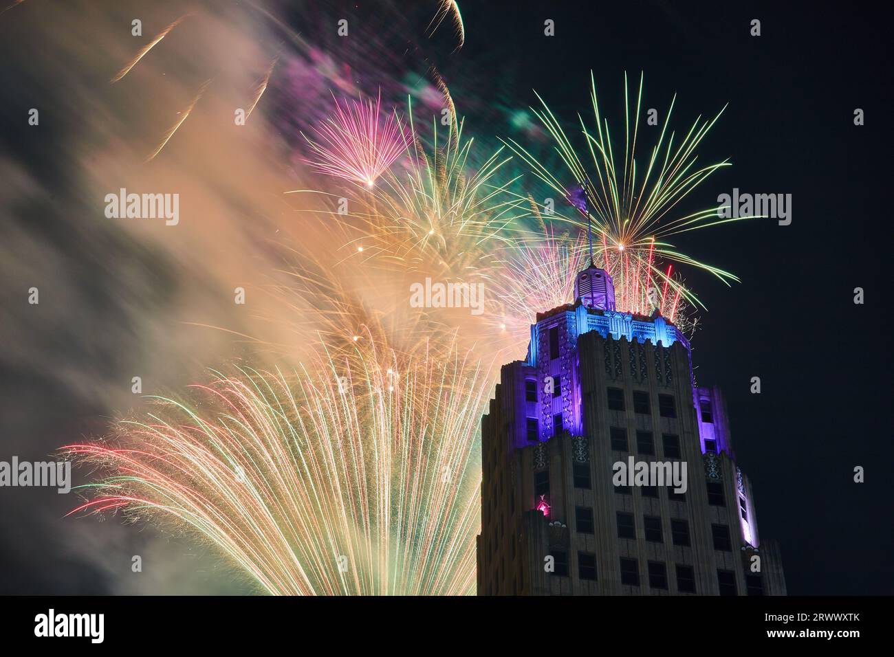 Zoomed in view of dazzling fireworks behind Lincoln Tower with purple ...