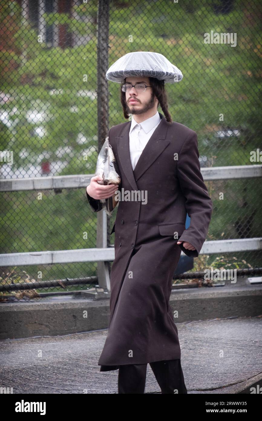 A young man returns from temple services and wears an improvised rain ...
