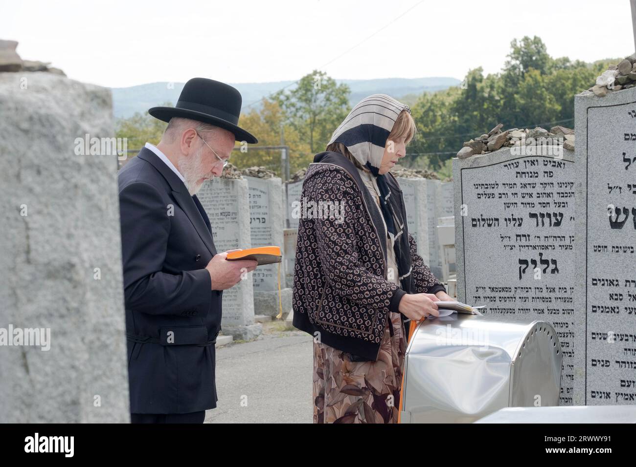 A hasidic couple pray at the headstone of a family member at the Old ...