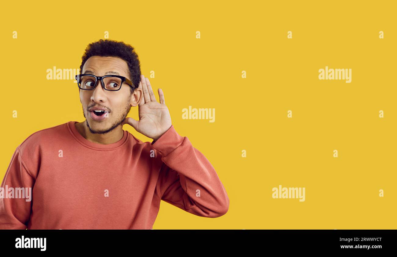 Curious guy puts his hand to his ear and listens to interesting news ...