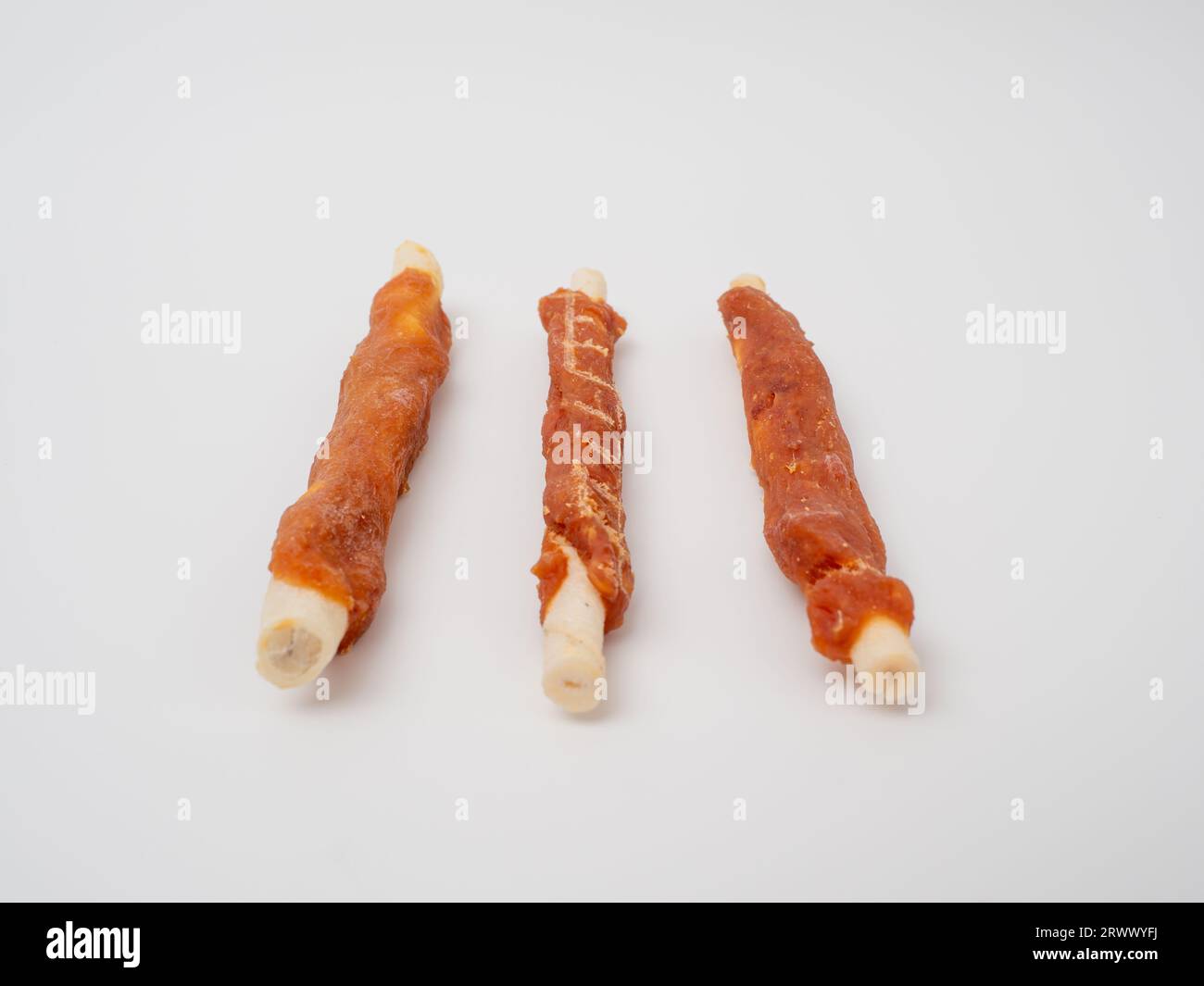 Dog chewing sticks on a white background. Treats for dogs Stock Photo ...