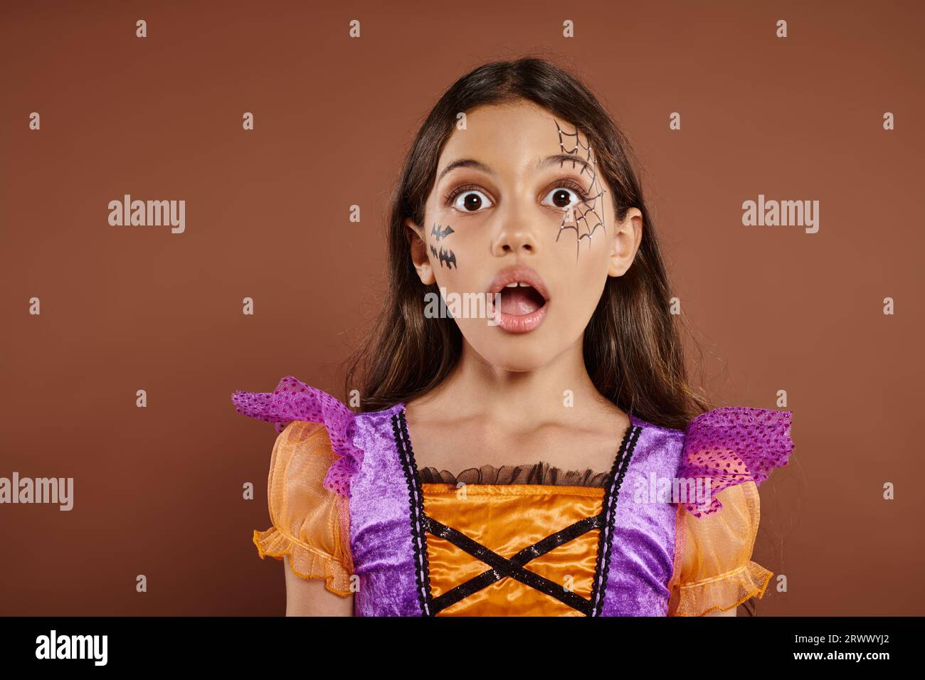 face expression, shocked girl in Halloween costume looking at camera on ...