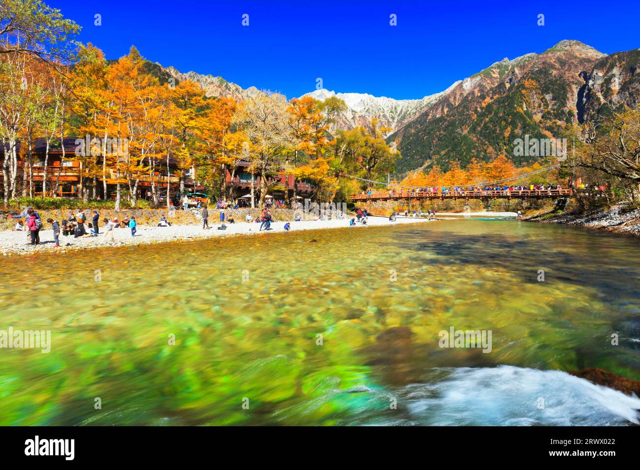 Kappa Bridge and snow-capped Hotaka mountain range in clear stream of ...