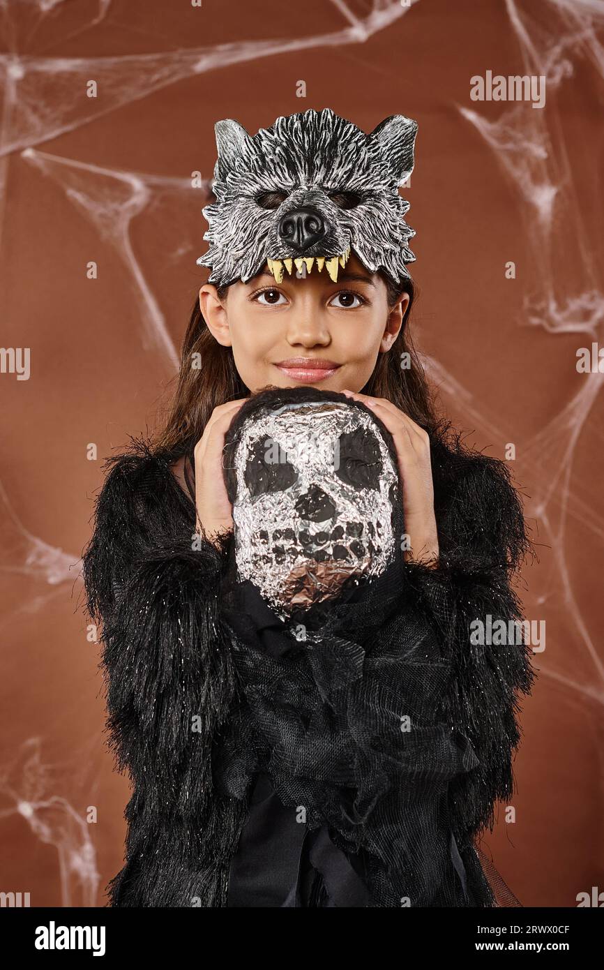 portrait of smiling girl in wolf mask and black attire hugging spooky ...