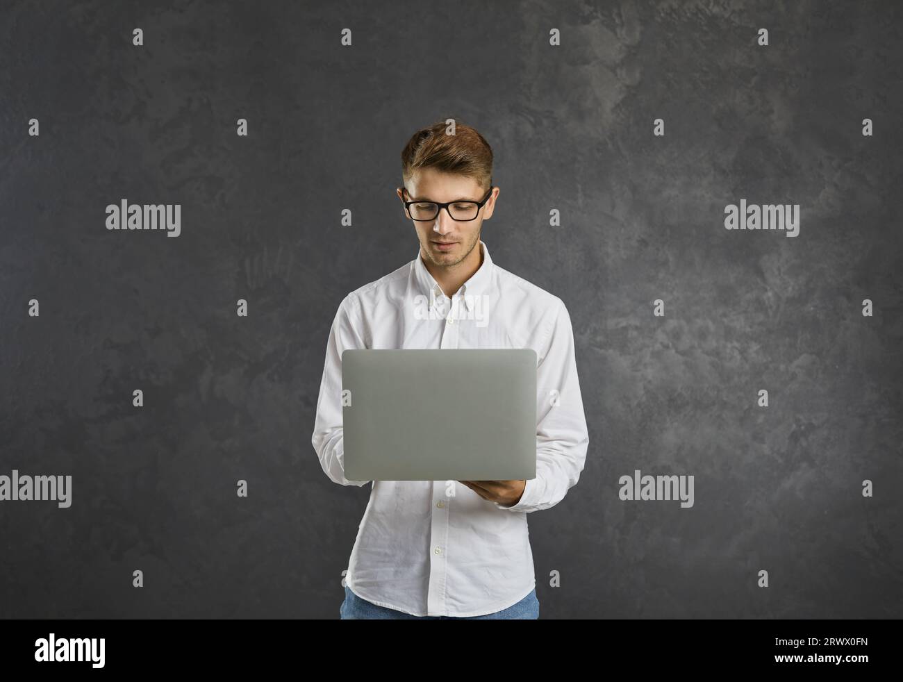 Concentrated smart young male programmer or employee working on startup ...