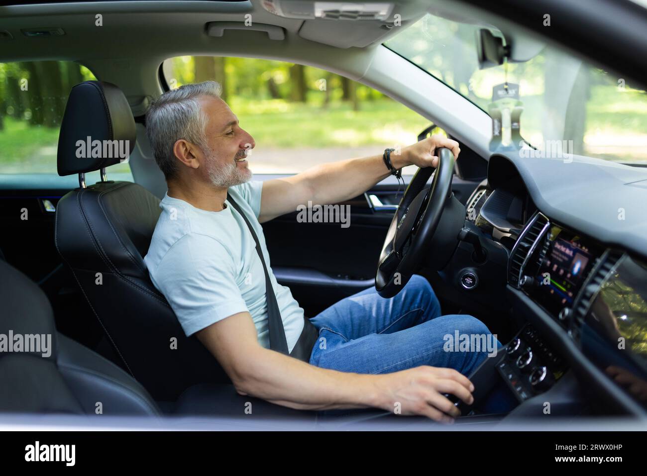 man in black suit holding hand on gear and smiling, driving car Stock ...