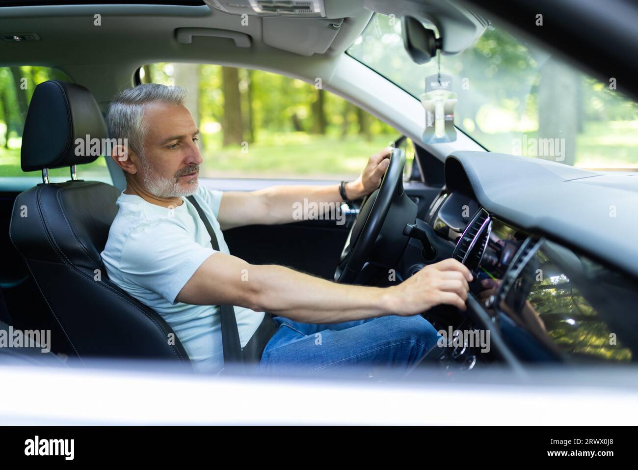 Man driver turning on radio in auto, over shoulder shot, copy space ...