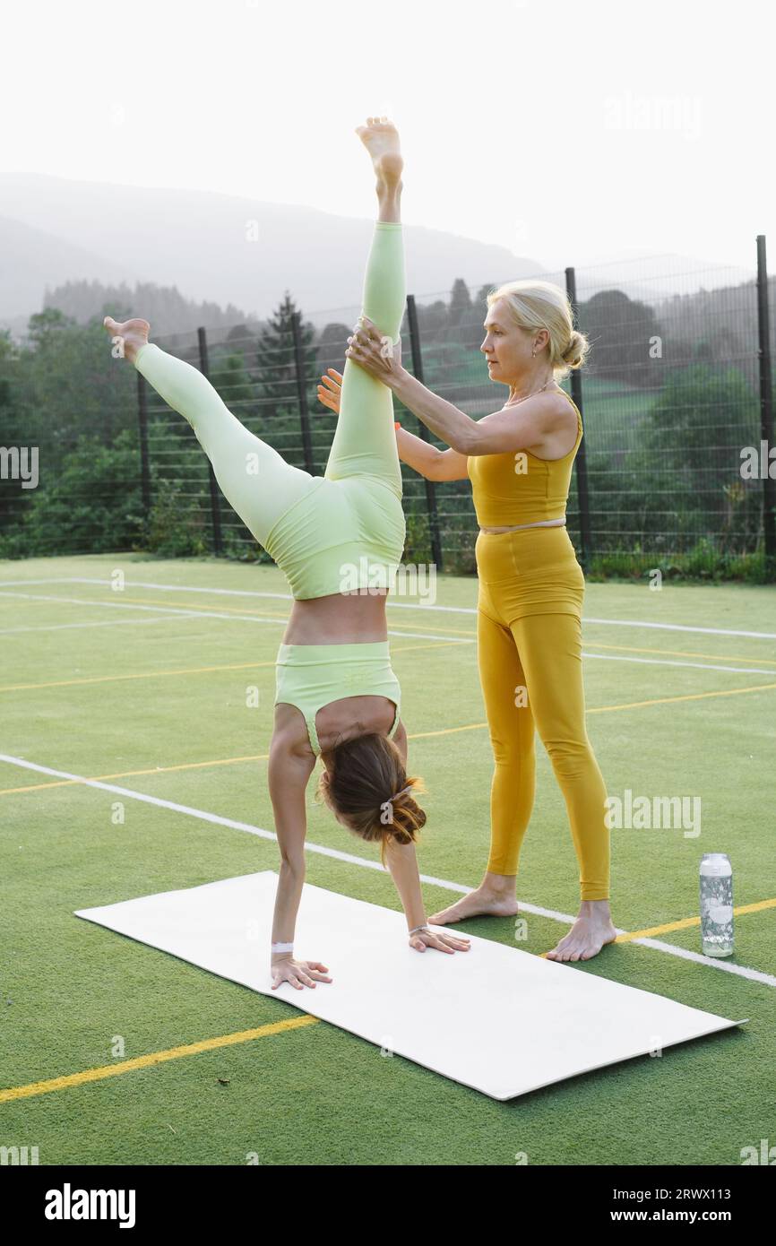 Two woman doing yoga outdoors Mother and adult daughter practicing ...