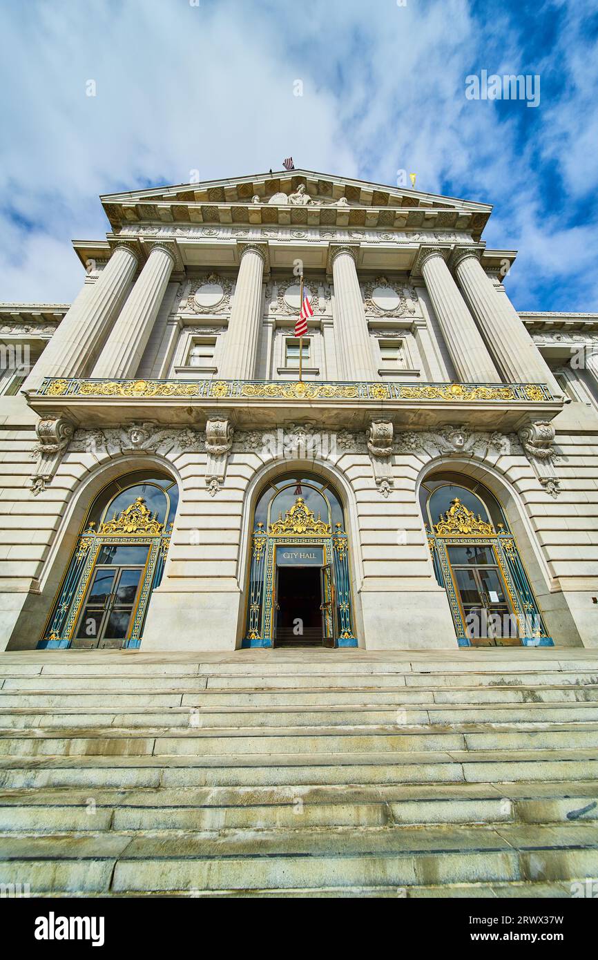 Steps leading into city hall gilded entrance with American flag over ...